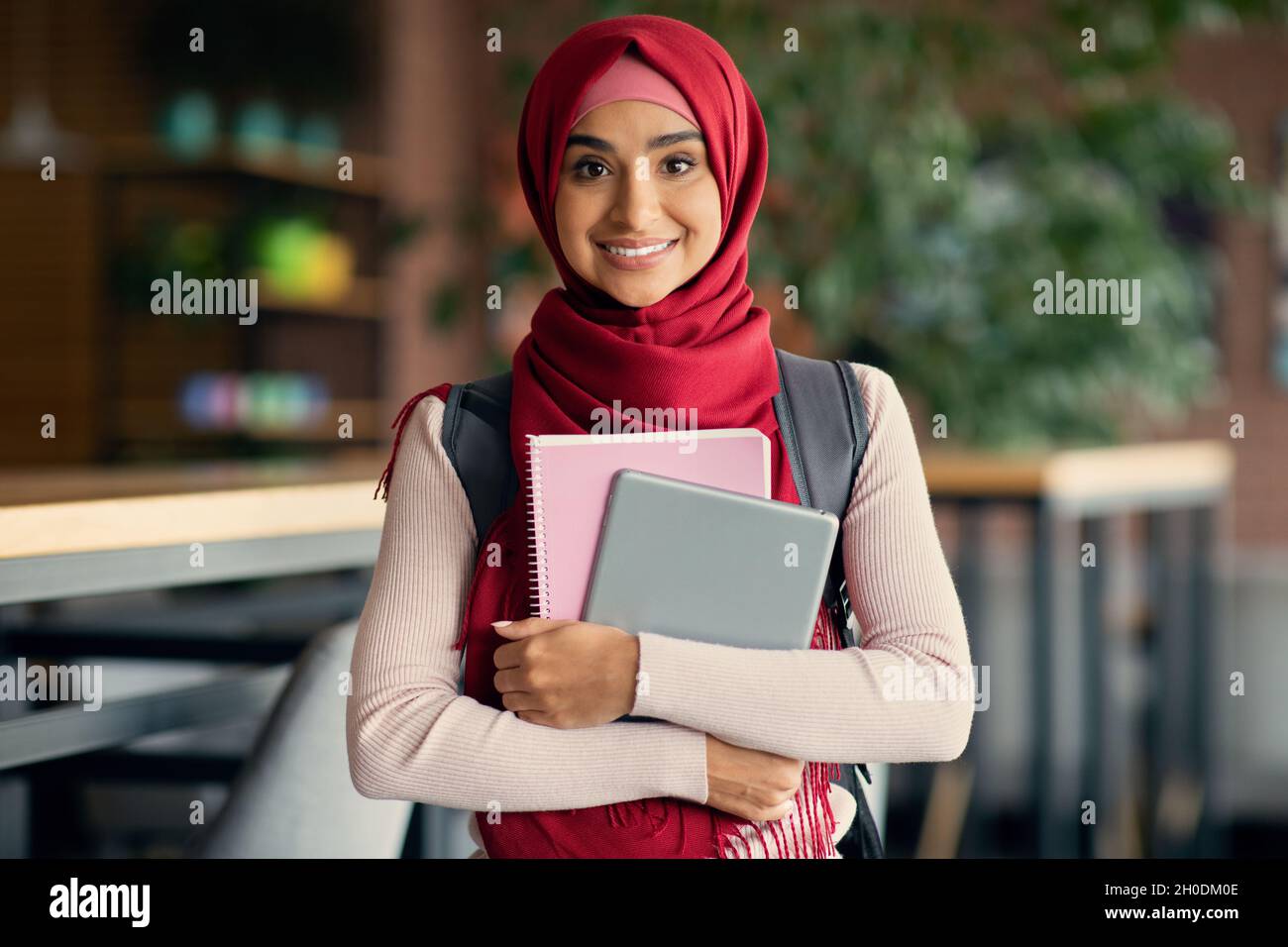 Happy muslim woman student with backpack and books at cafe Stock Photo ...