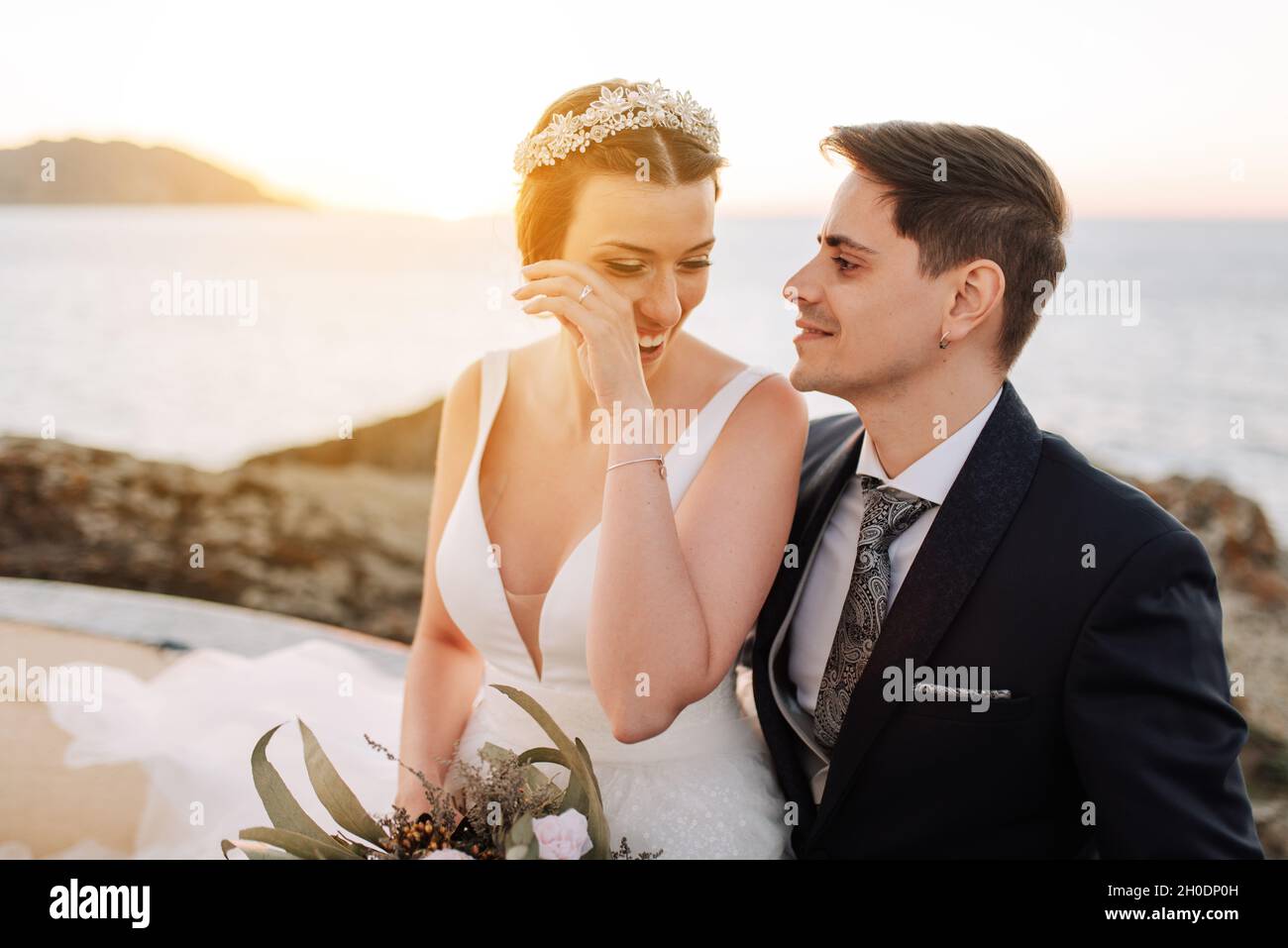 Portrait of a just married couple with the bride crying and smiling ...