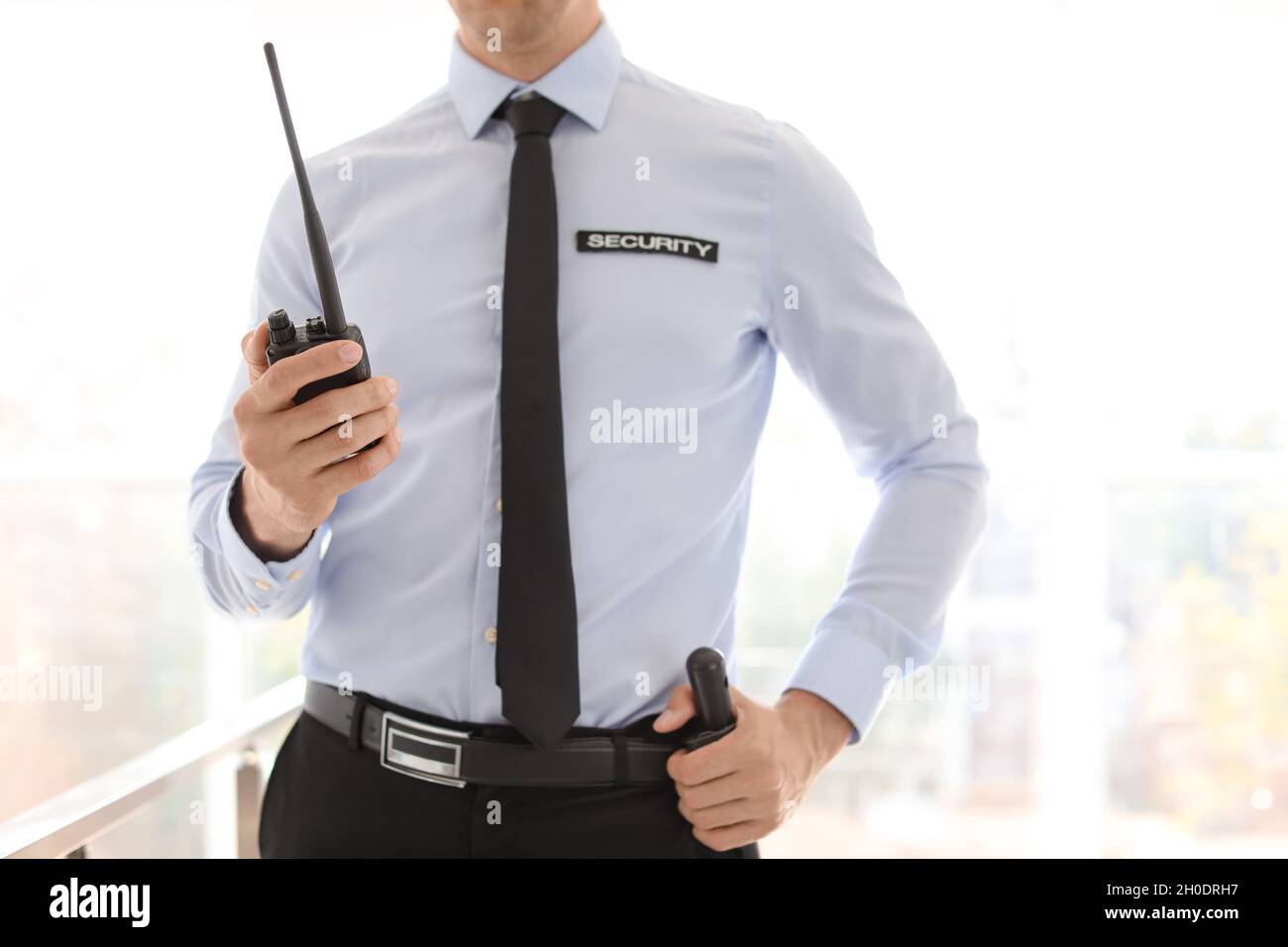 Male security guard with portable radio transmitter indoors Stock Photo ...