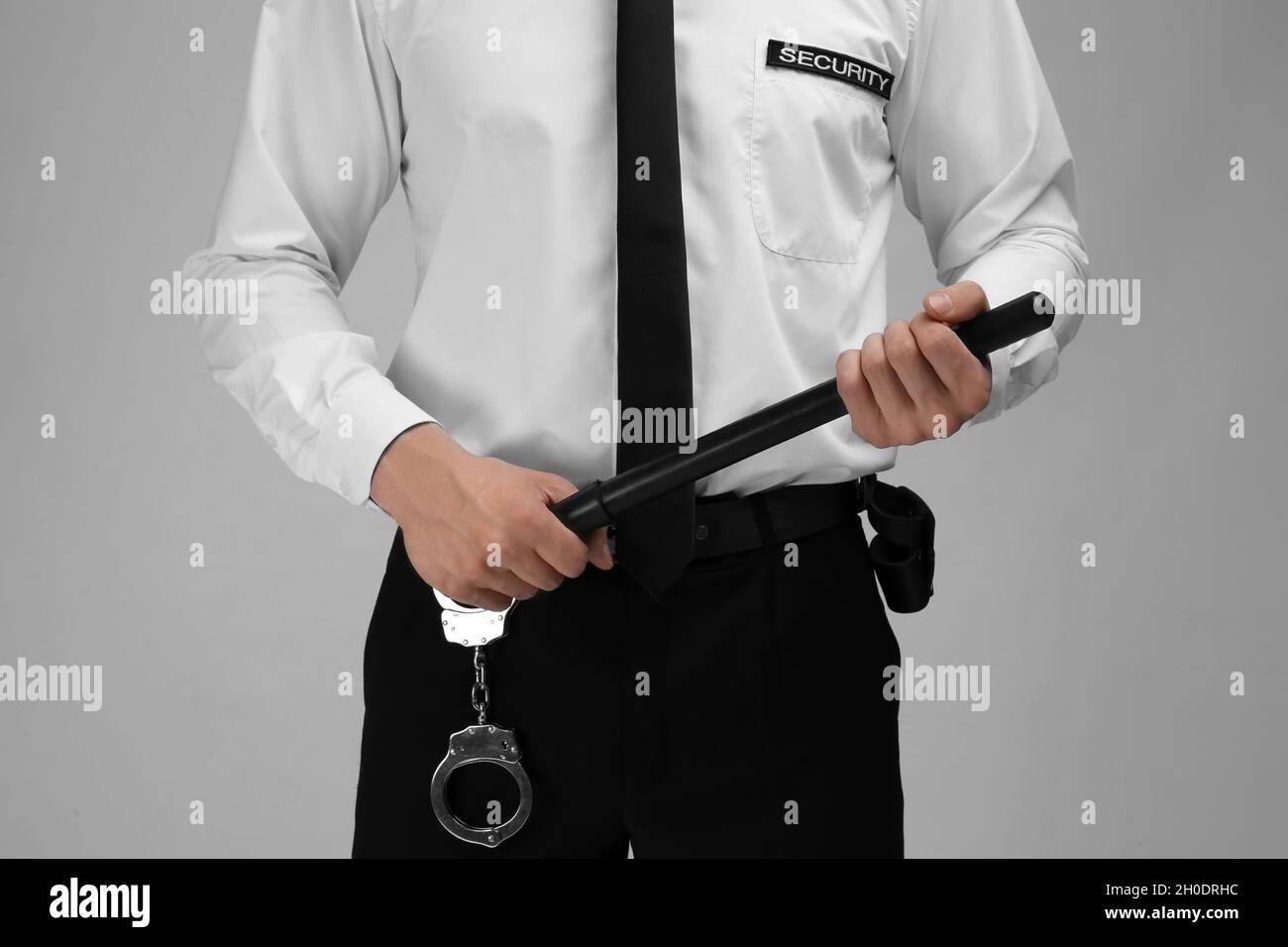 Male security guard with police baton on color background Stock Photo ...