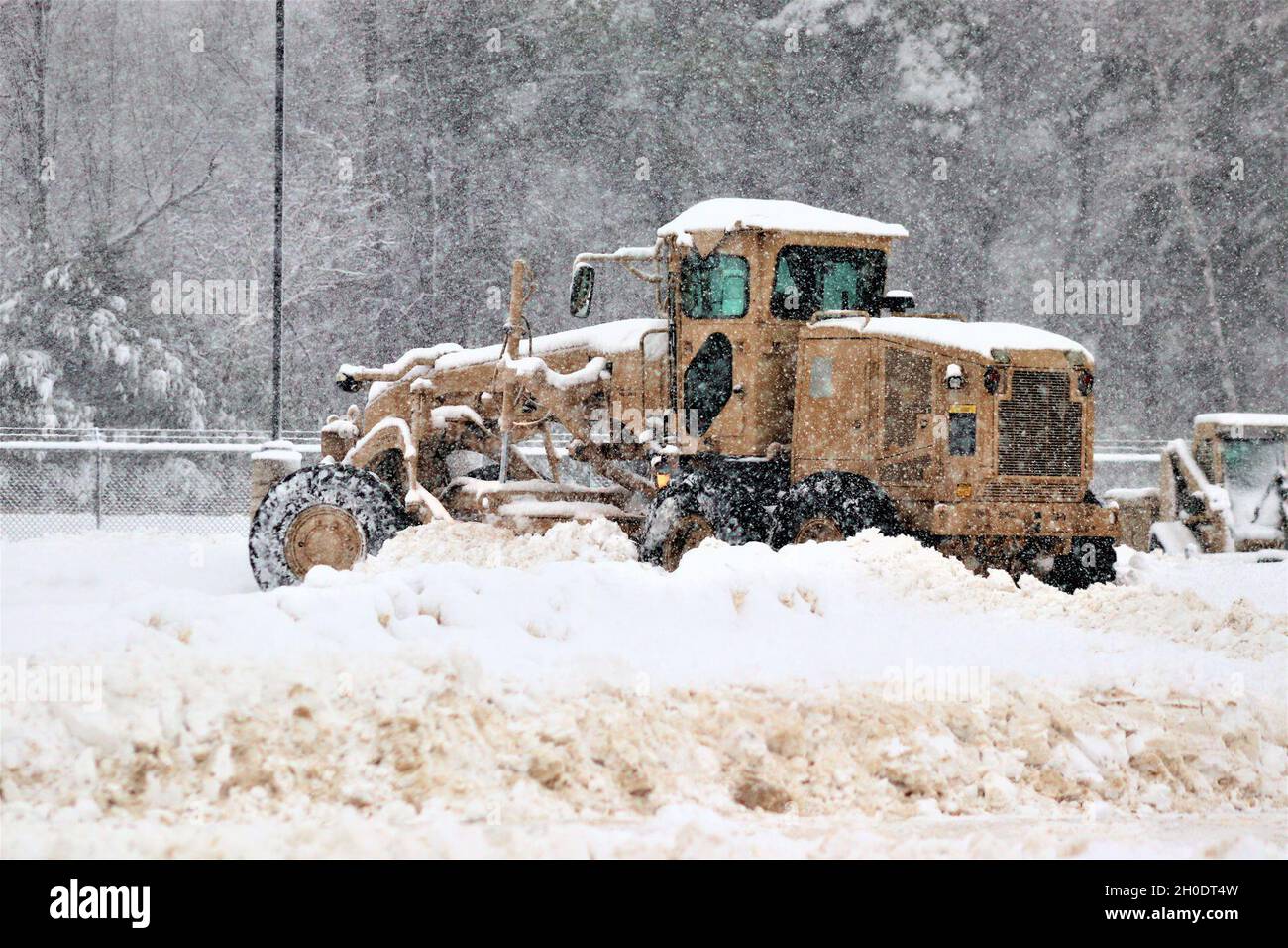 A Regional Training Site-Maintenance staff member drives a grader to ...