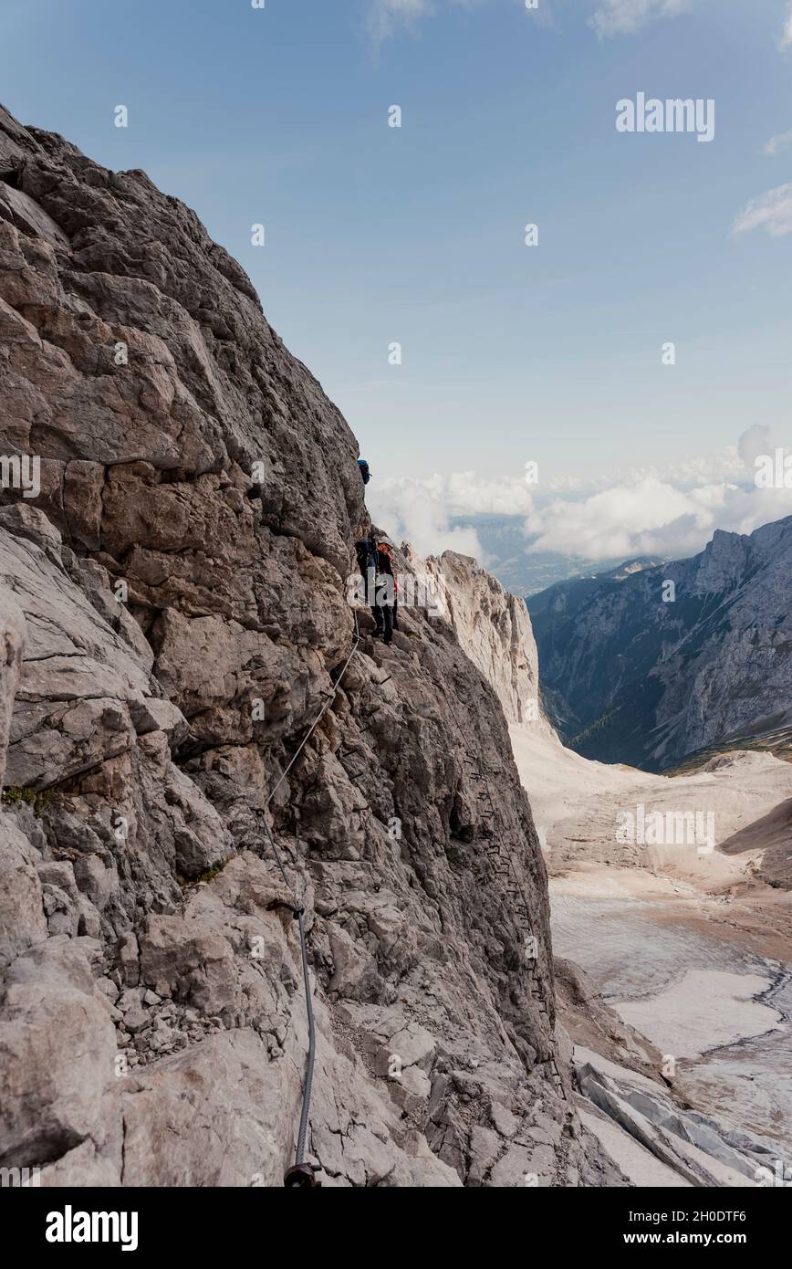 Man standing on a steep mountain route Stock Photo - Alamy
