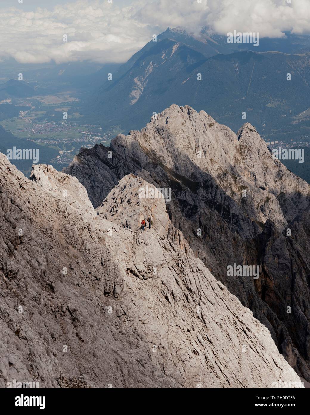Two person standing on ridge line Stock Photo - Alamy