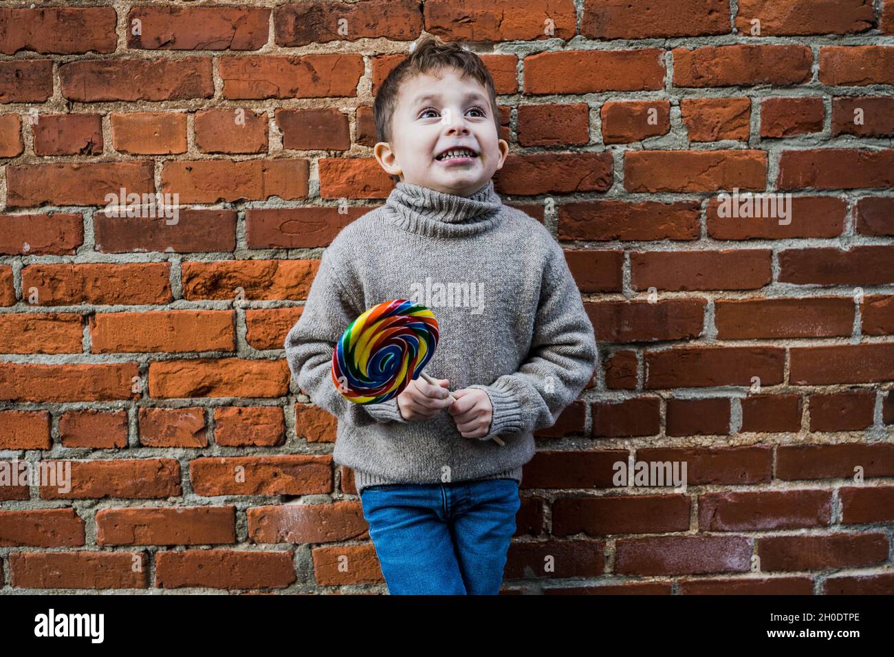Little boy making silly faces with a giant lollipop Stock Photo - Alamy