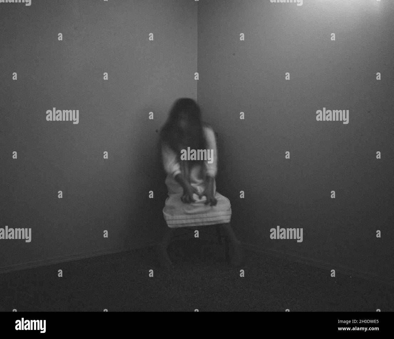Scary ghost girl sitting in spooky dark corner of room Stock Photo - Alamy