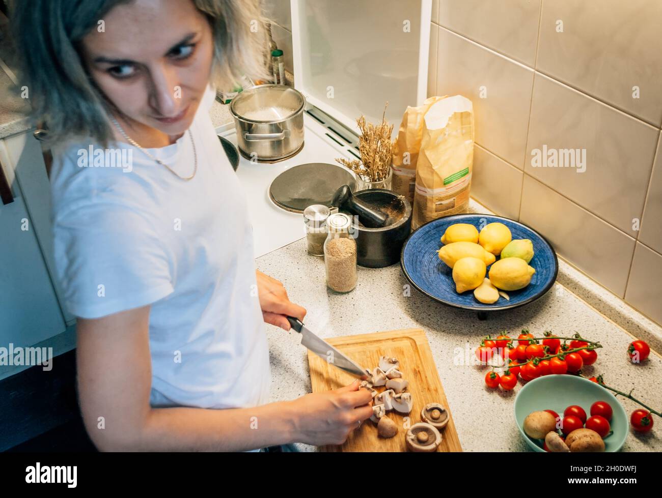 A woman looks back over her shoulder while cooking dinner Stock Photo ...