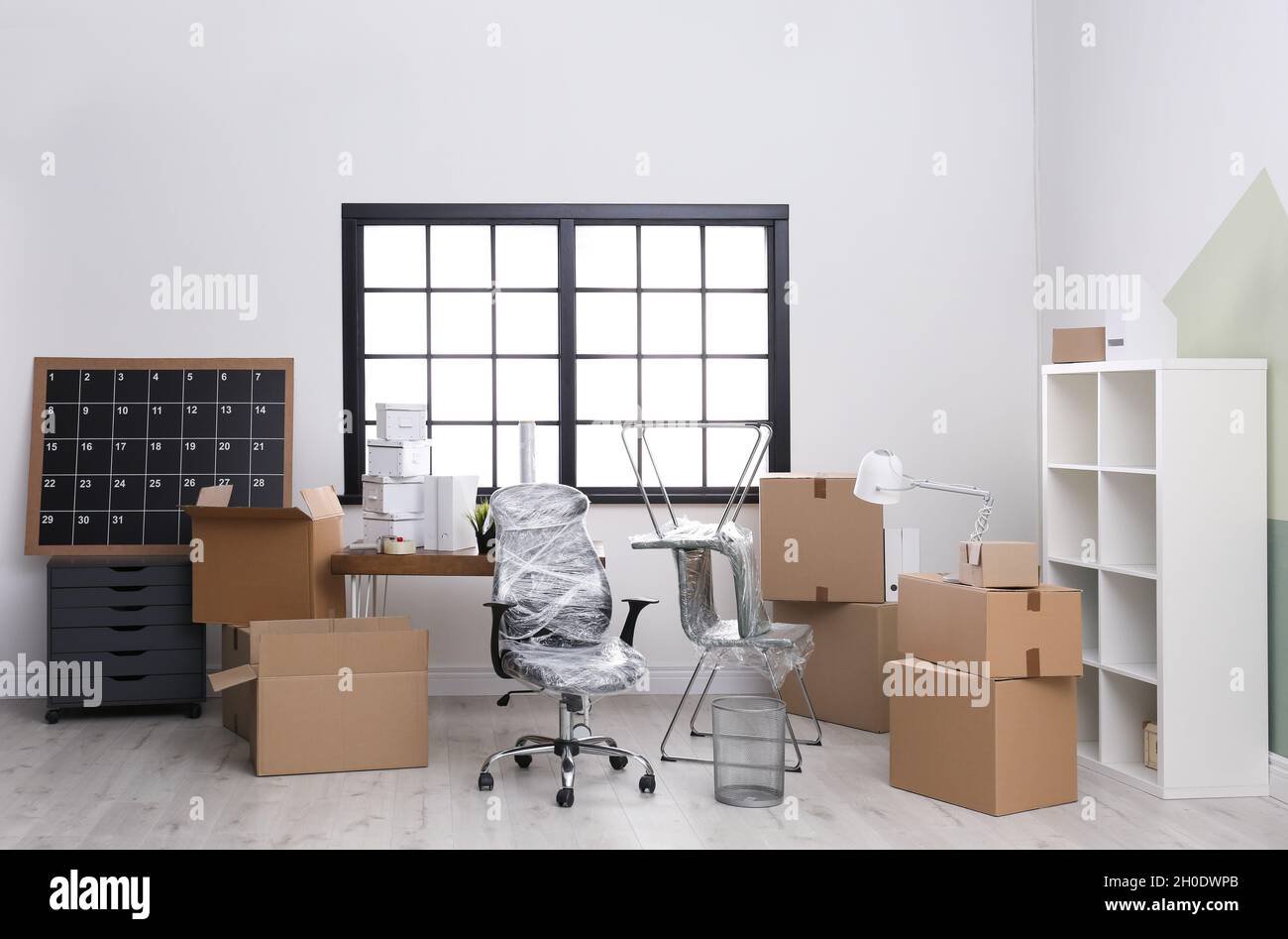 Moving boxes and furniture in new office Stock Photo - Alamy