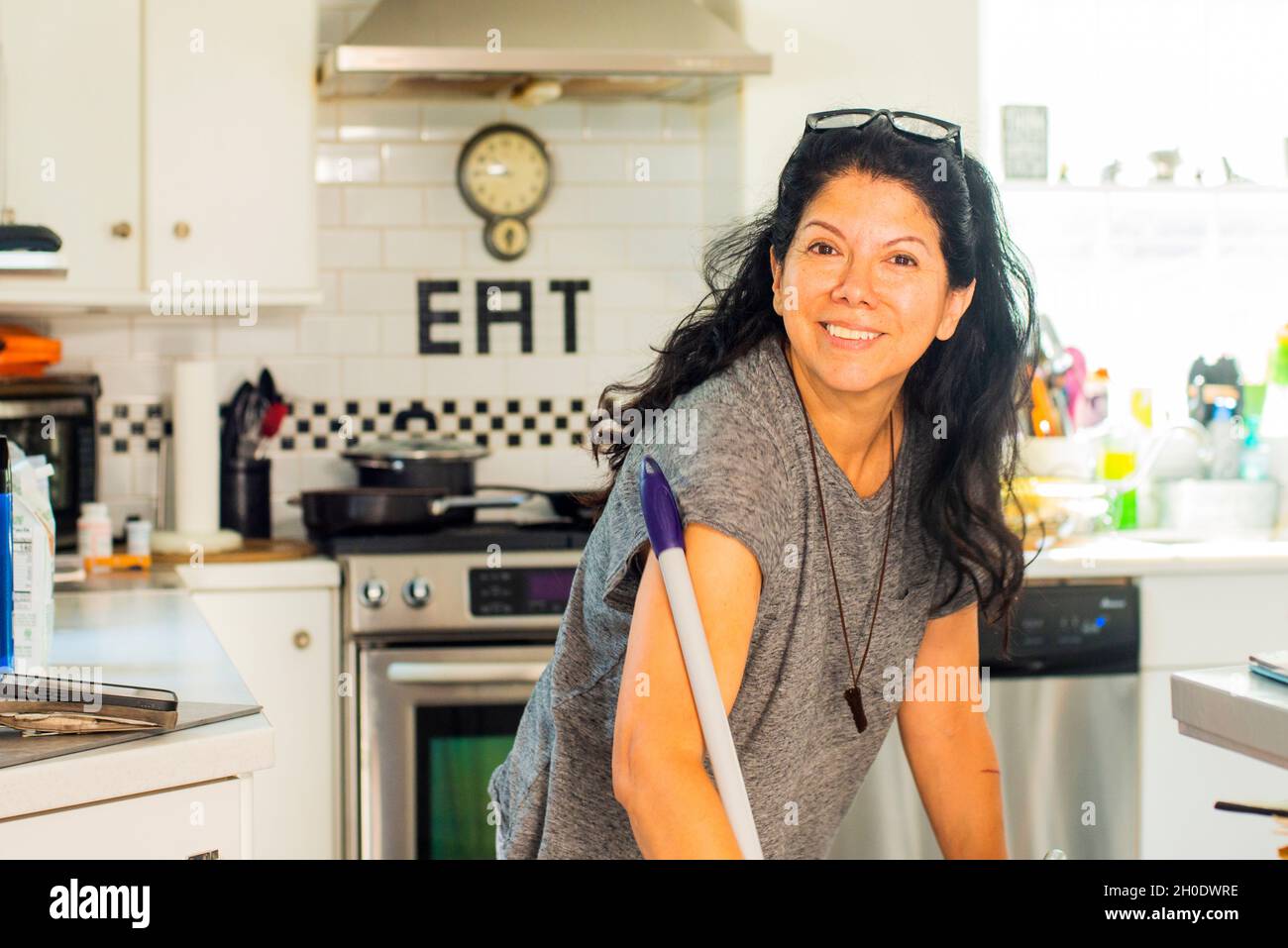 Latin woman cleaning The kitchen Stock Photo - Alamy