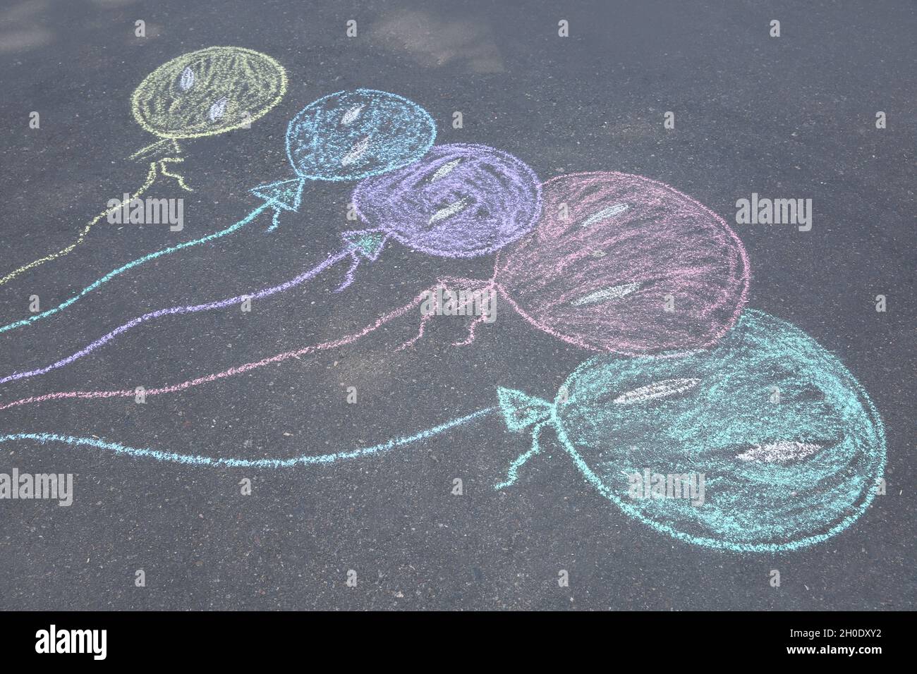 Child's chalk drawing of balloons on asphalt Stock Photo - Alamy