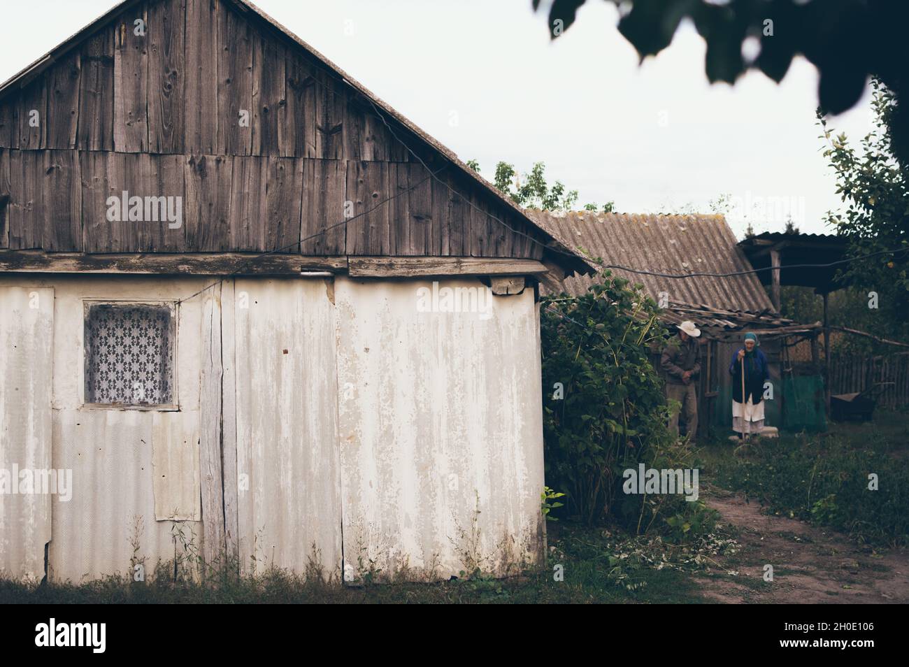An old rustic whitewashed house with a triangular roof and a curtained ...