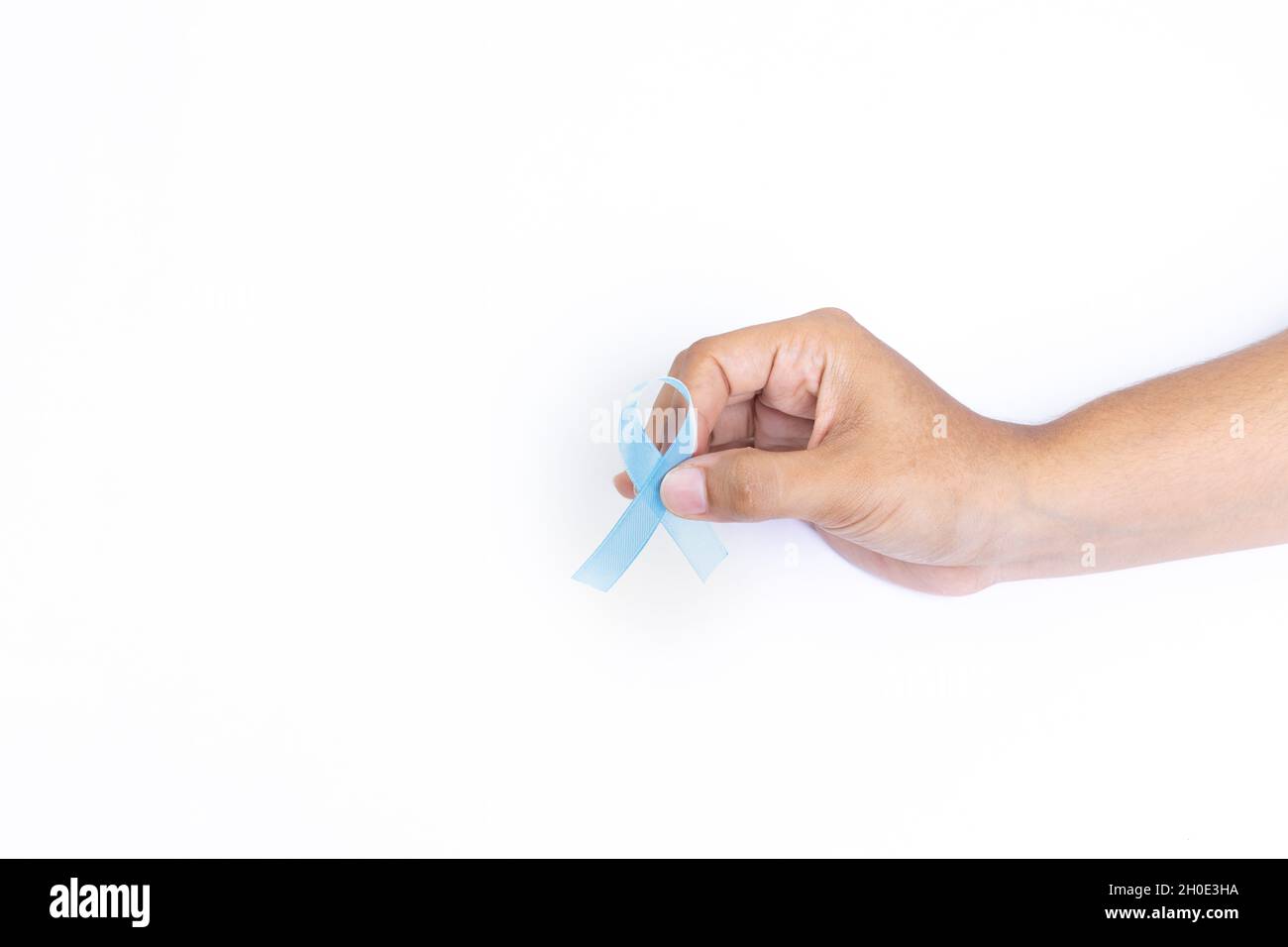 Hand holding prostate cancer awareness blue ribbon over isolated white ...