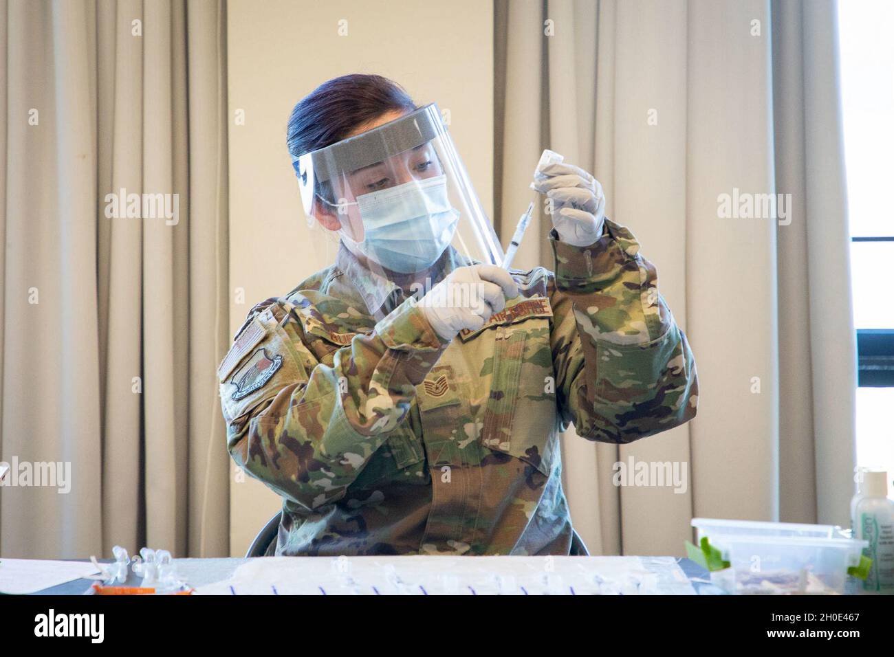 Tech. Sgt. Danielle Burns, 102nd Medical Group, prepares a syringe from ...