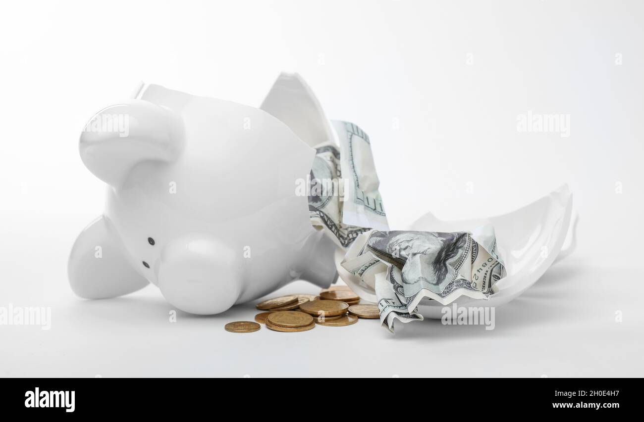 Broken piggy bank with coins and banknotes on white background Stock ...