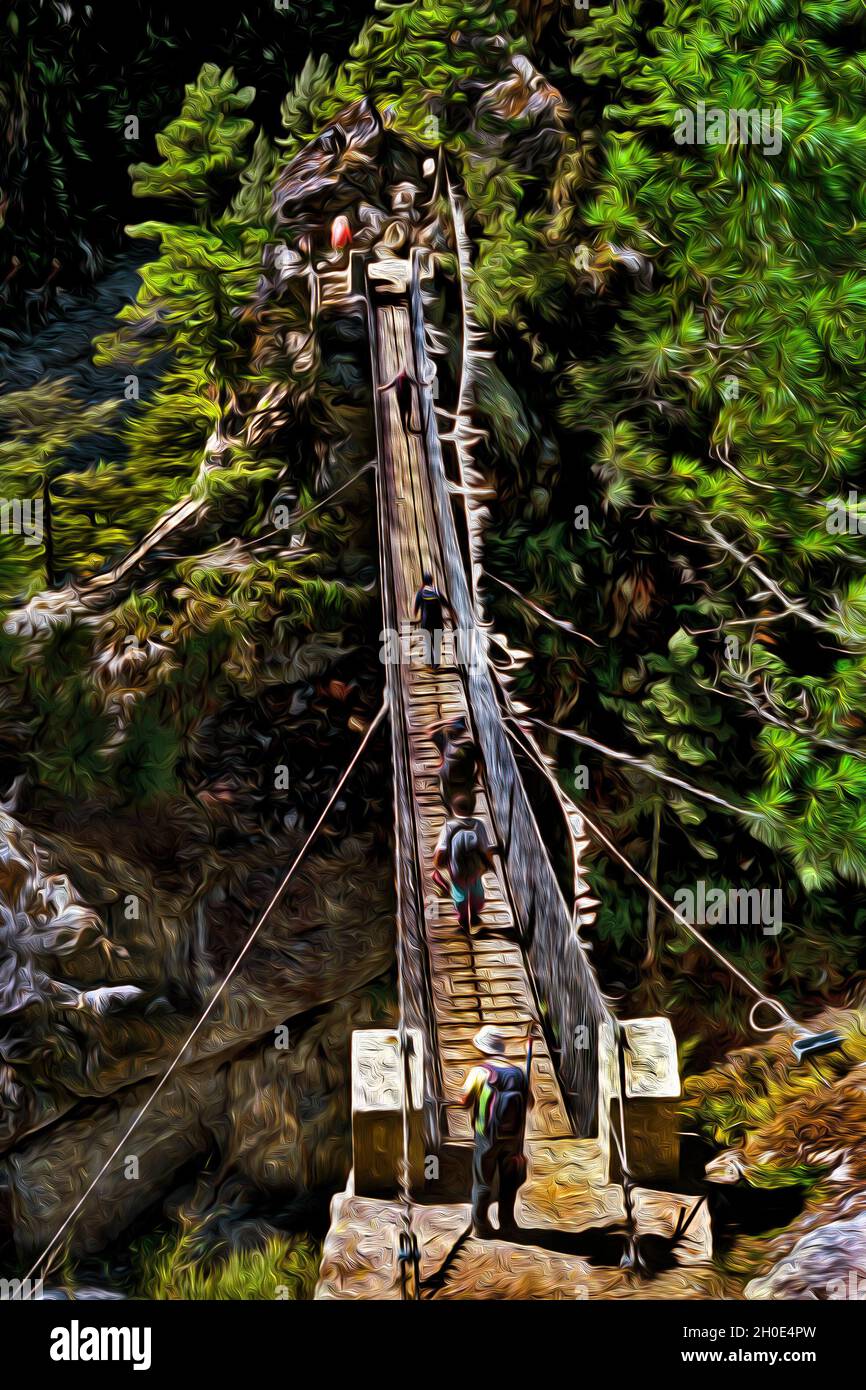 People crossing precarious suspension bridge on trail at the Himalaya ...