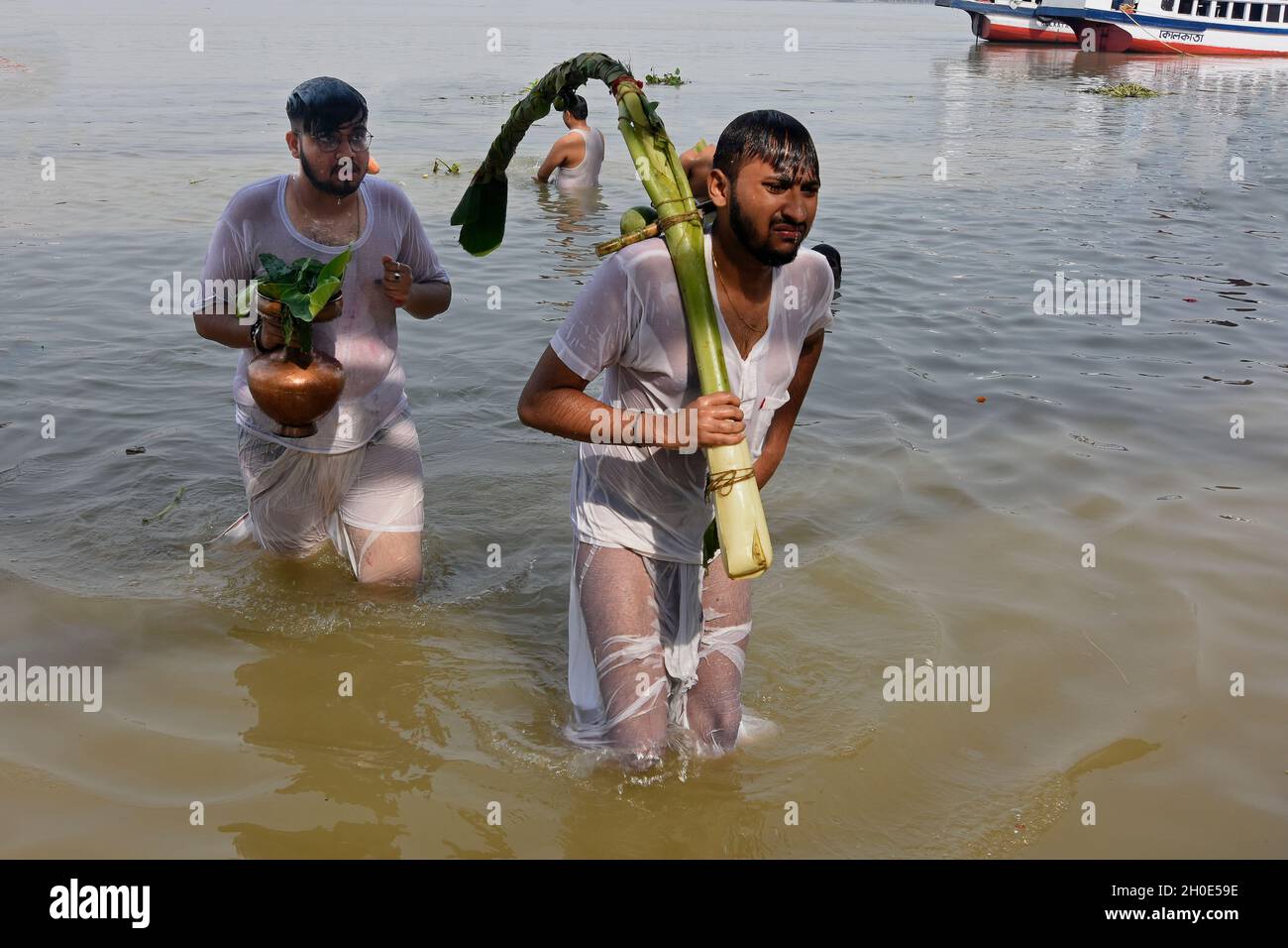 Kolkata, India. 12th Oct, 2021. Hindu devotees give holy dip with ...