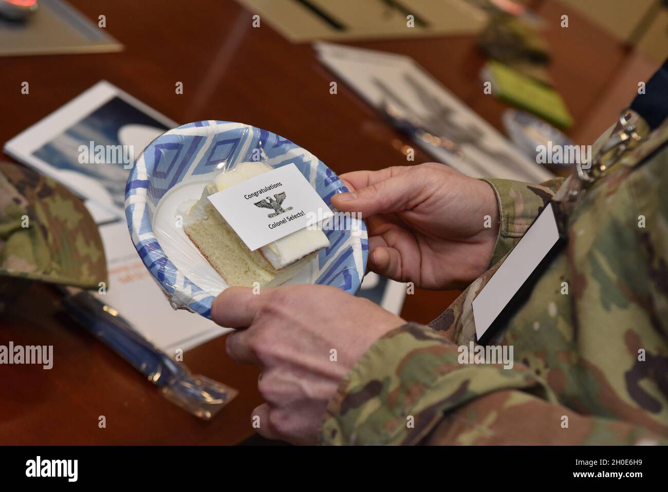 A U.S. Air Force Colonel select holds a piece of cake during a ...