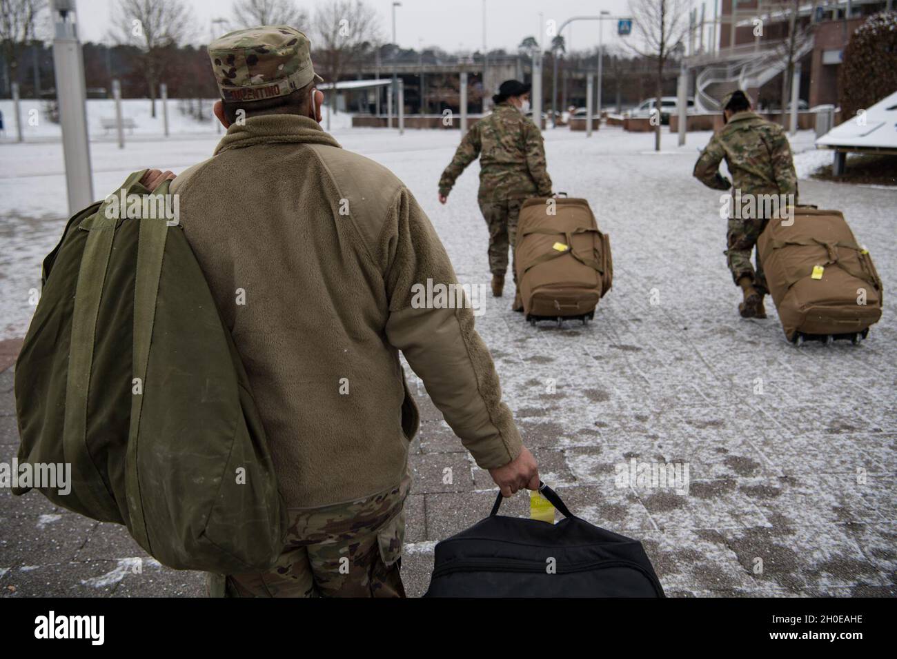 Members of the Deployment Transition Center carry the bags of ...