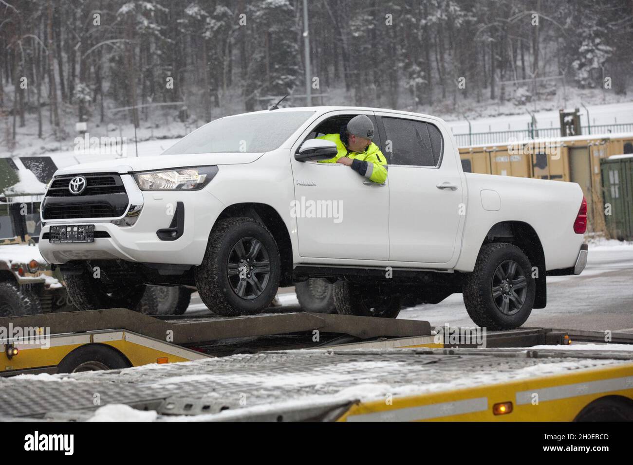 Autohaus Dummeyer employees unload a vehicle from a car carrier trailer ...