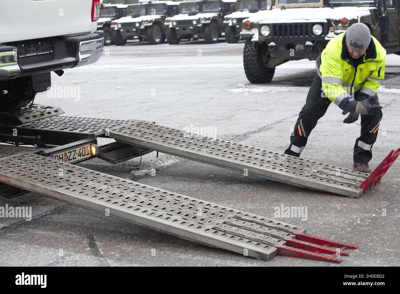 Autohaus Dummeyer employees unload a vehicle from a car carrier trailer ...