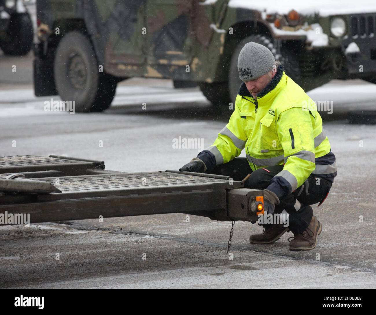 Autohaus Dummeyer employees unload a vehicle from a car carrier trailer ...