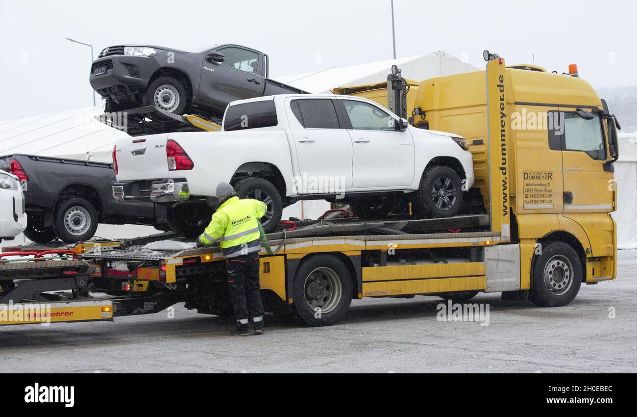 Autohaus Dummeyer employees unload a vehicle from a car carrier trailer ...