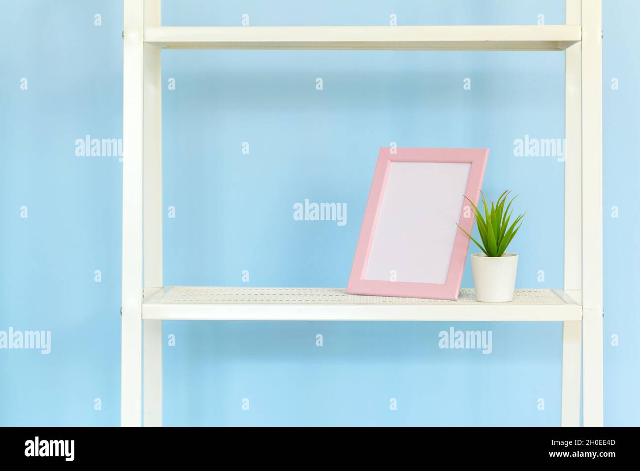 White metal rack with books against blue background Stock Photo - Alamy