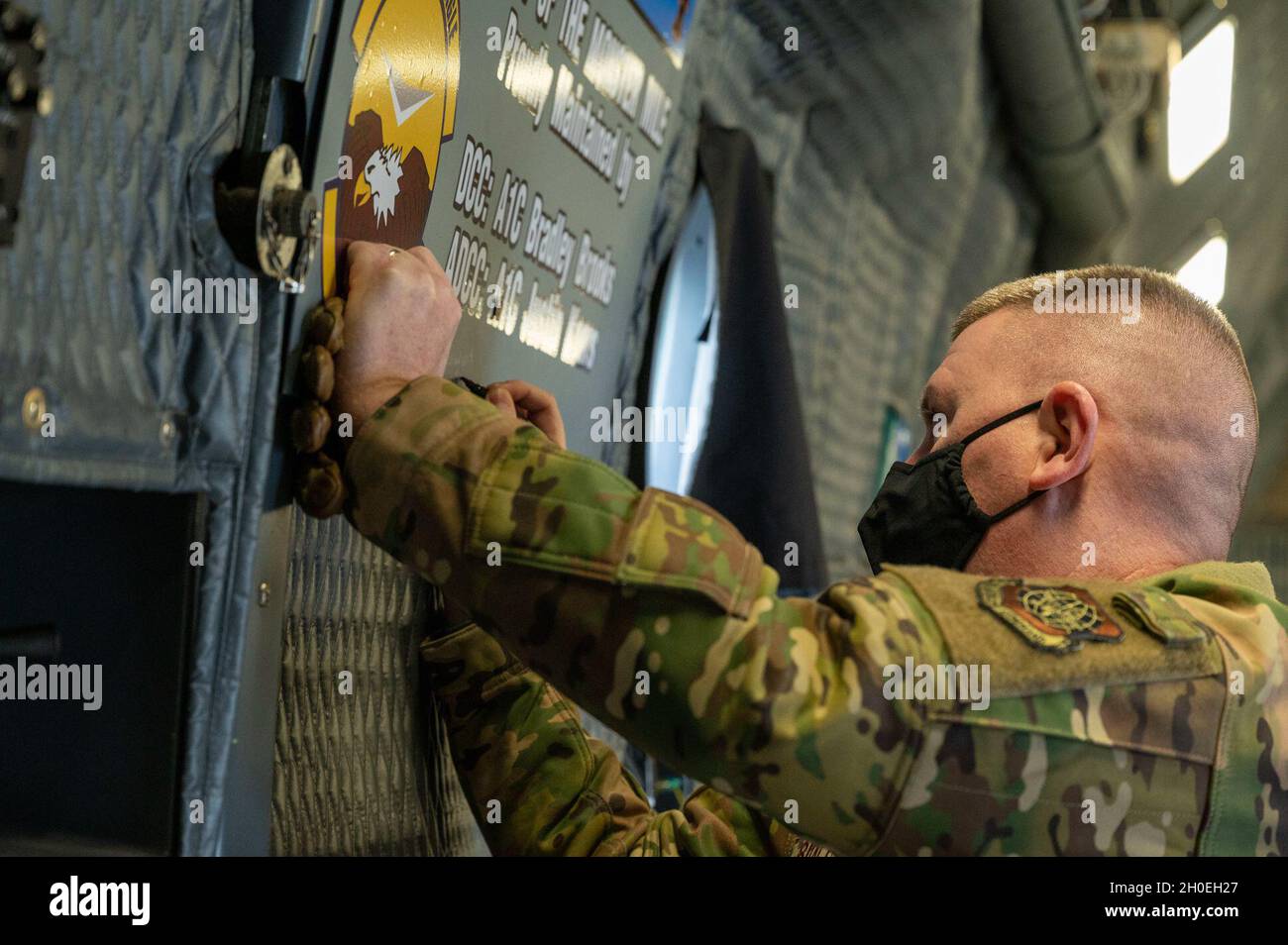 Chief Master Sgt. Chad Bickley, 18th Air Force command chief, signs a ...