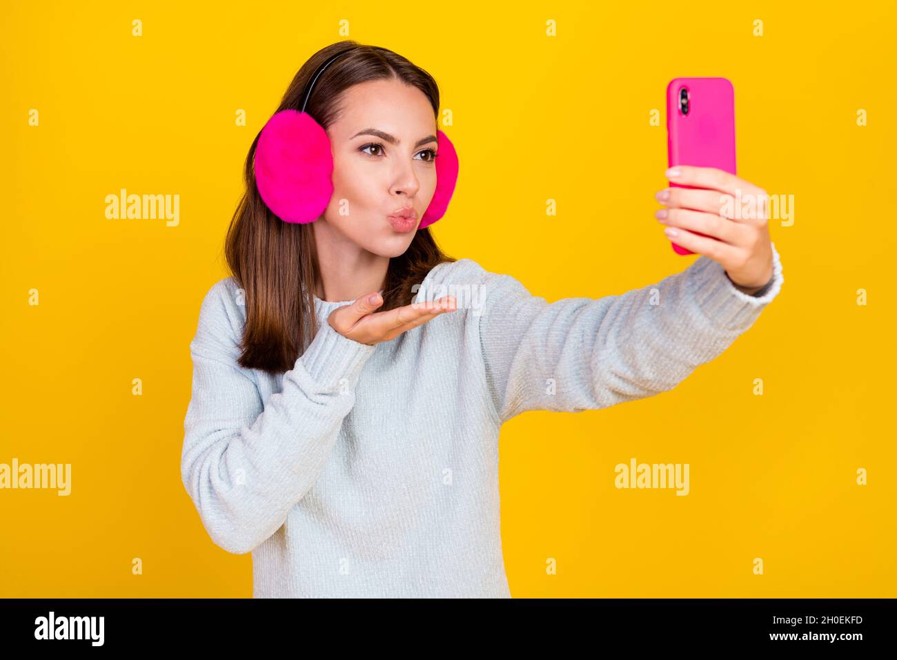Photo of flirty happy young brunette woman wear ear warmer make selfie ...