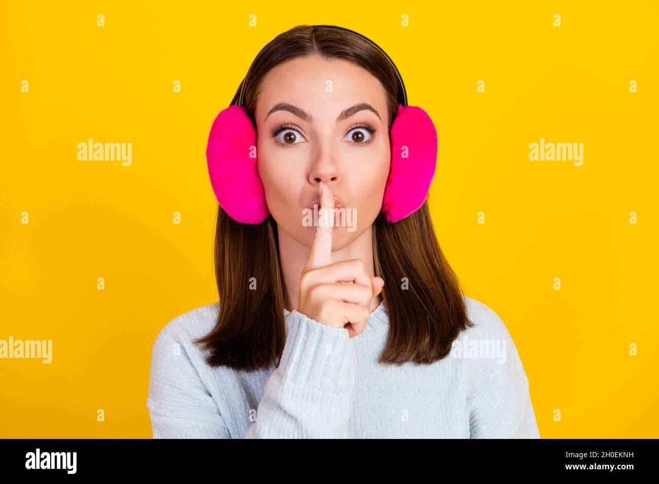 Photo of mute voiceless young woman wear earmuff hold finger lips mouth ...