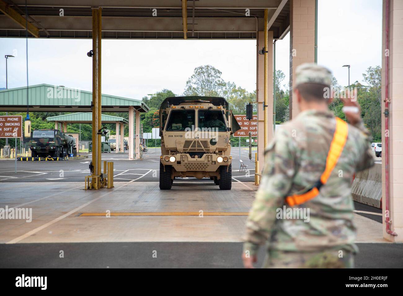 A soldier from the 25th Infantry Division, guides a vehicle into a ...
