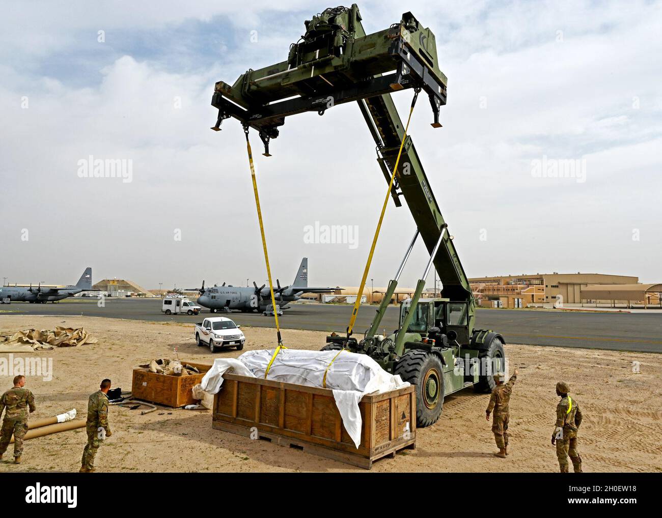 U.S. Air Force and U.S. Army machinery operate together to transfer a ...