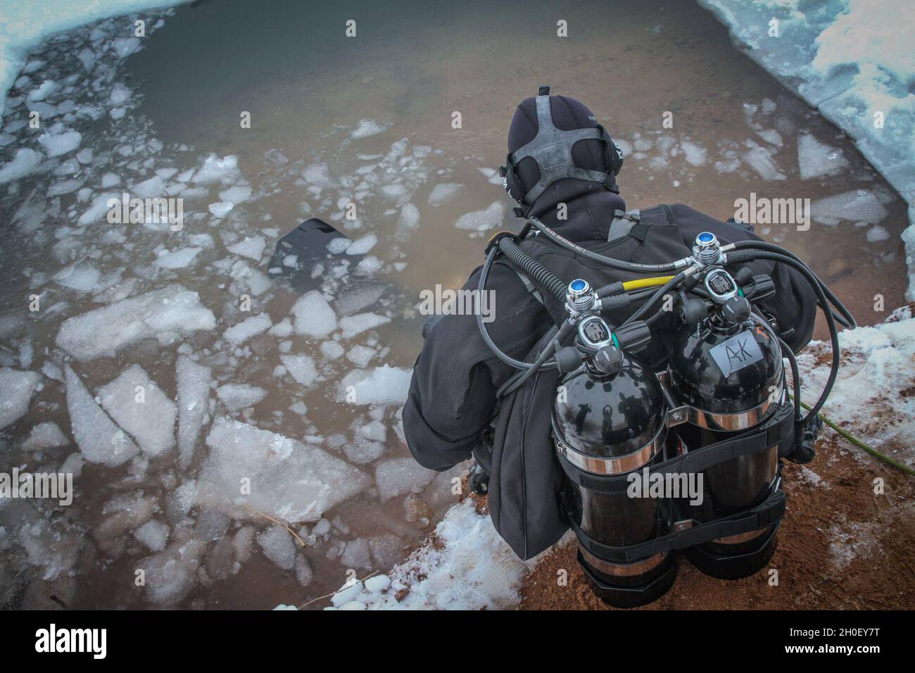 A Green Beret diver prepares to dive into a frozen reservoir during ice ...