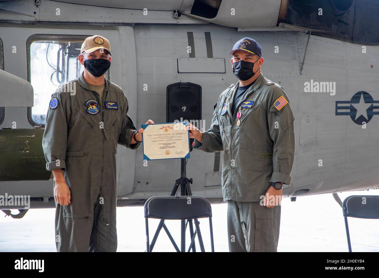 Cdr. Christopher Carreon receives the Meritorious Service Medal from Rear Admiral John Menoni ...
