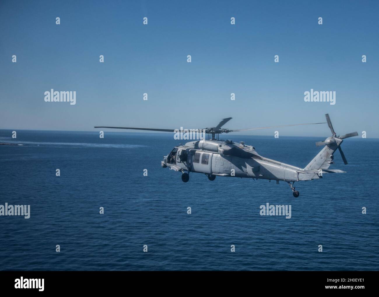 A U.S. Navy MH-60S Seahawk flies over the Pacific Ocean, Feb. 18, 2021 ...