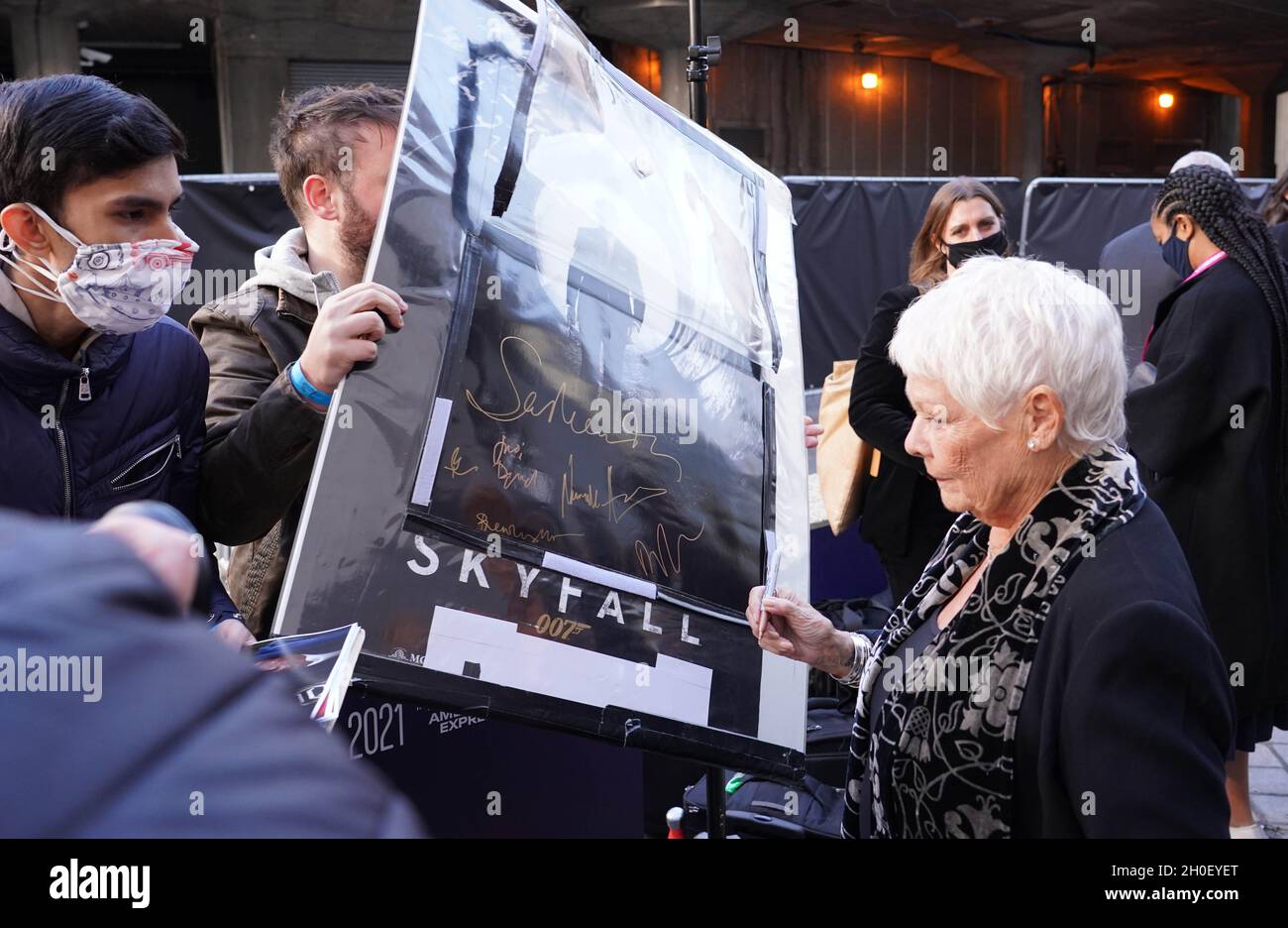 Dame Judi Dench signs a poster as she arrives for the European premiere ...