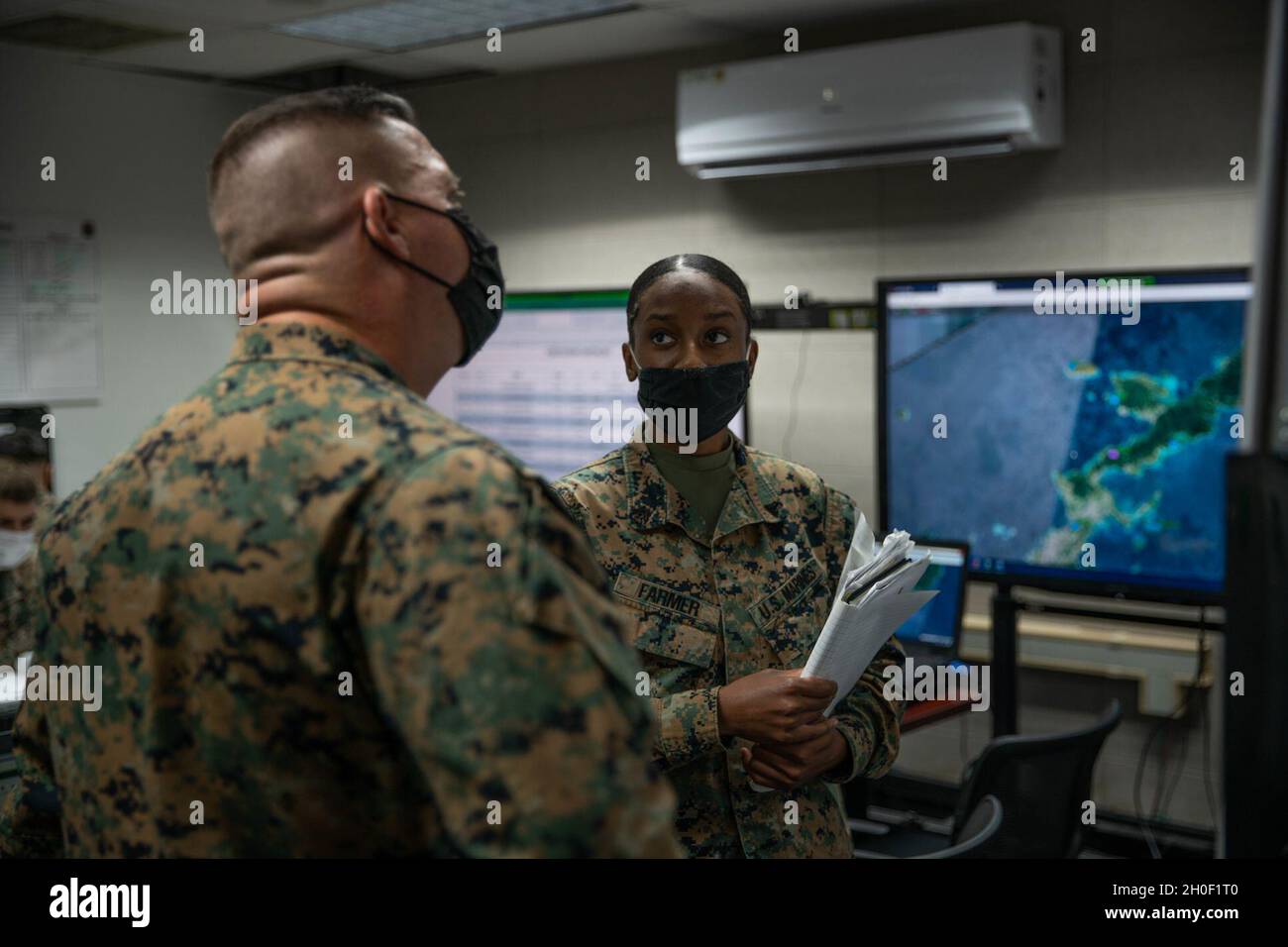 U.S. Marine Corps Col. Travis Gaines, commanding officer, is briefed by ...