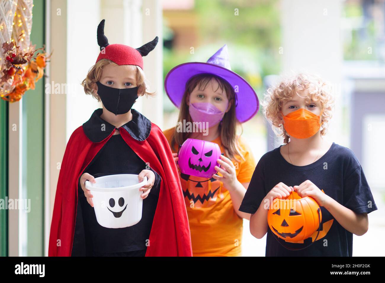 Kids trick or treat in Halloween costume and face mask. Children in ...