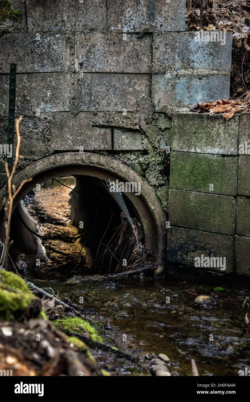 Drainage ditch stream runs under roadway Stock Photo - Alamy