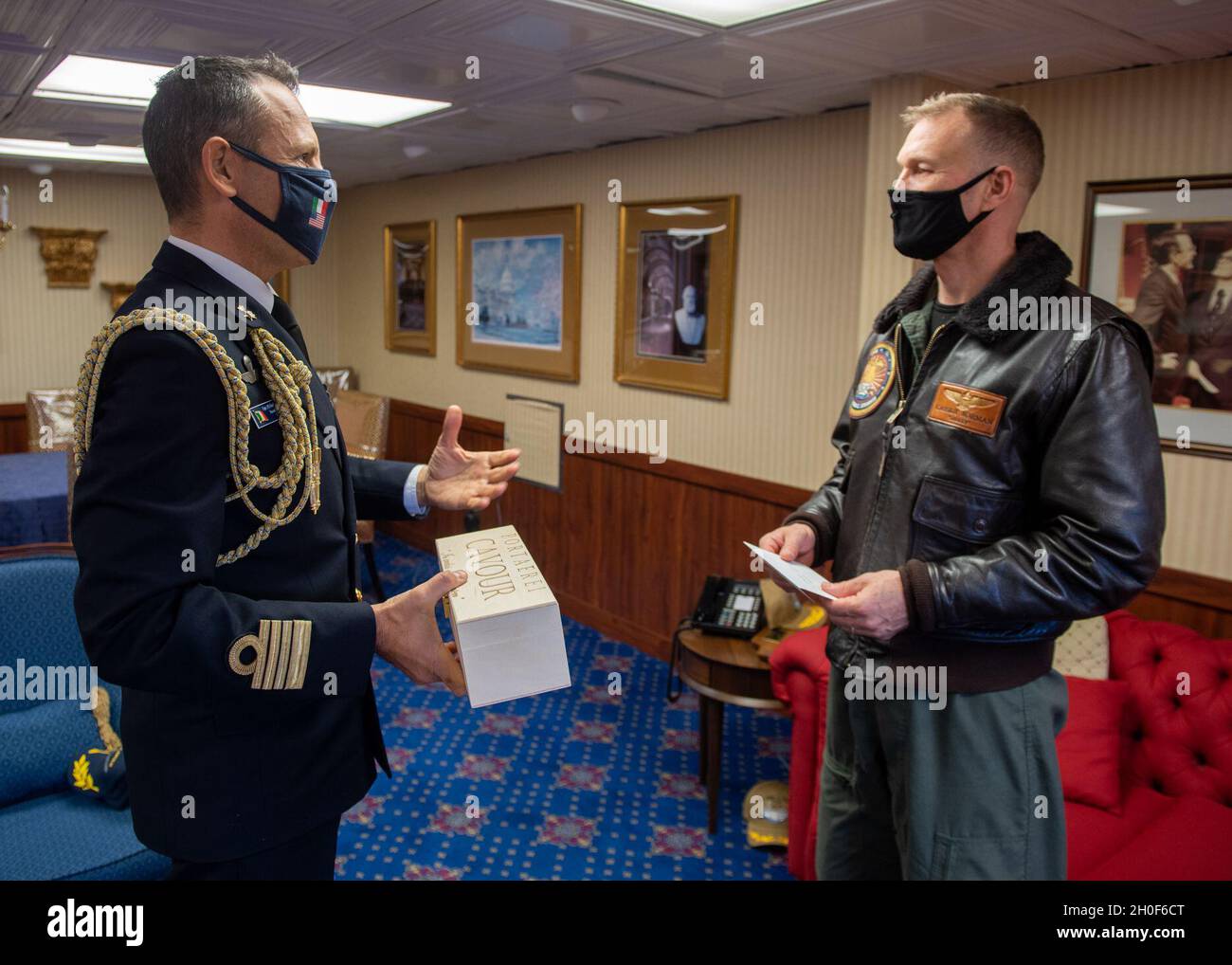 Italian Navy Capt. Gianfranco Vizzini, naval attaché, left, presents a ...