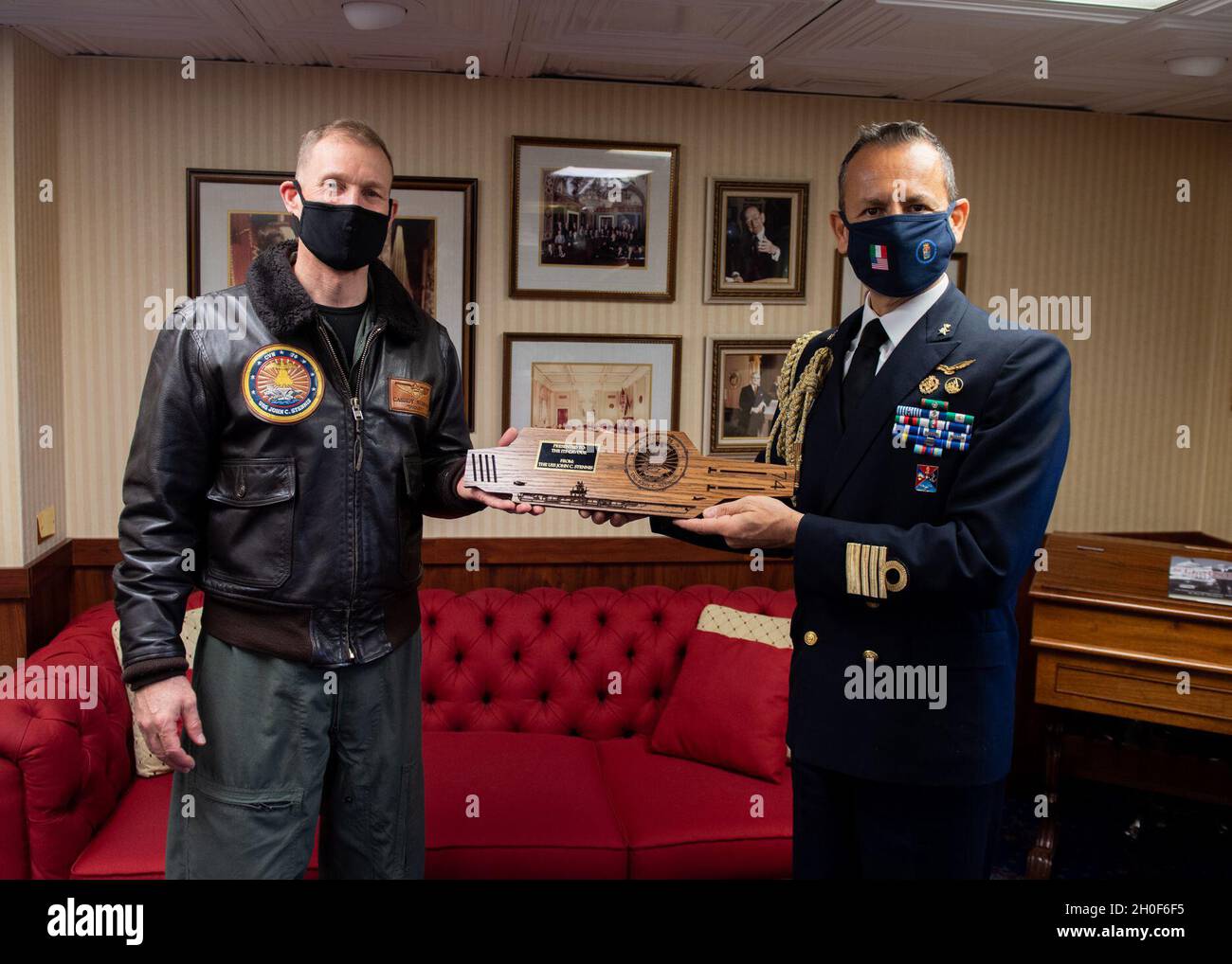 Italian Navy Capt. Gianfranco Vizzini, naval attaché, right, receives a ...