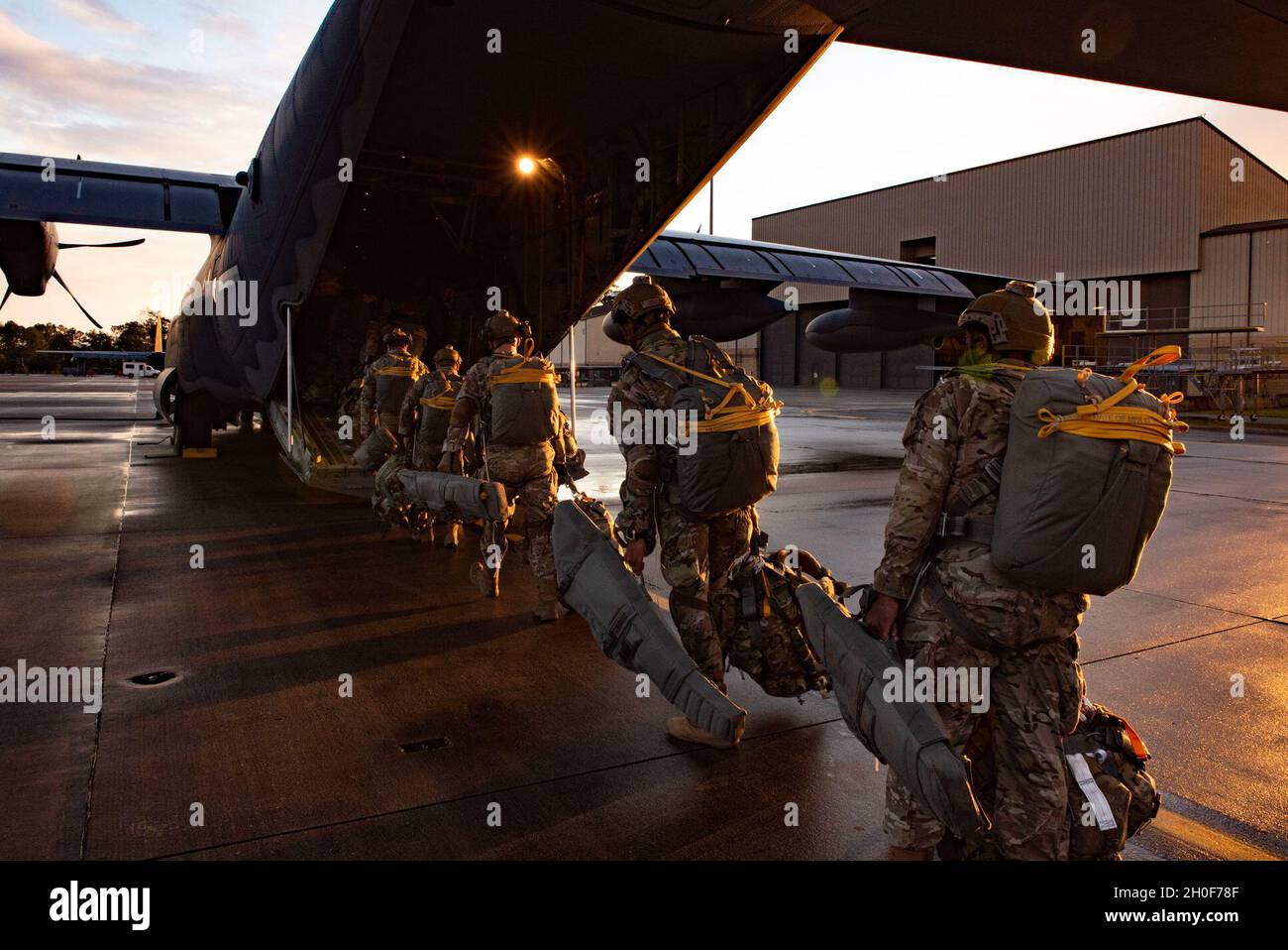 Airmen assigned to the 820th Base Defense Group load on to an HC-130J ...