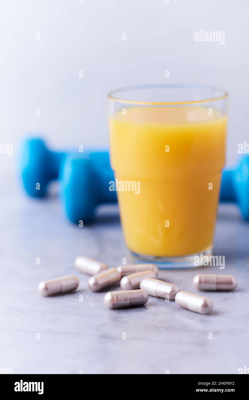 Sport Supplements ( Carnitine Capsules ) on stone background. Glass of ...