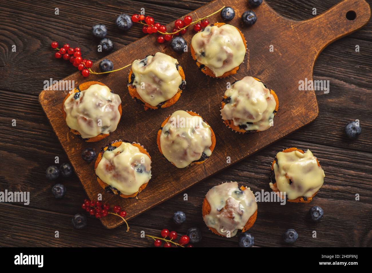 Homemade muffins with red currants and blueberry, covered with white ...