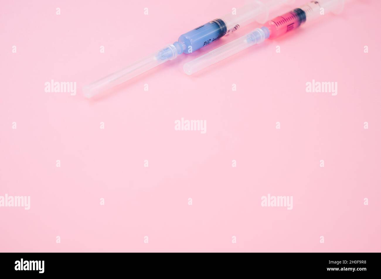 sterilized injection syringe on a pink background Stock Photo - Alamy