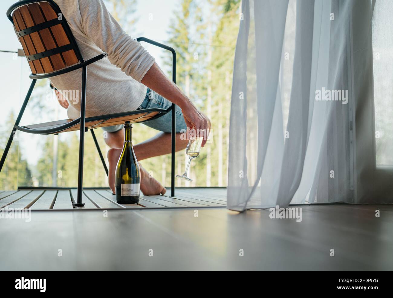 Alone man sitting on the country house balcony and enjoying the natural ...