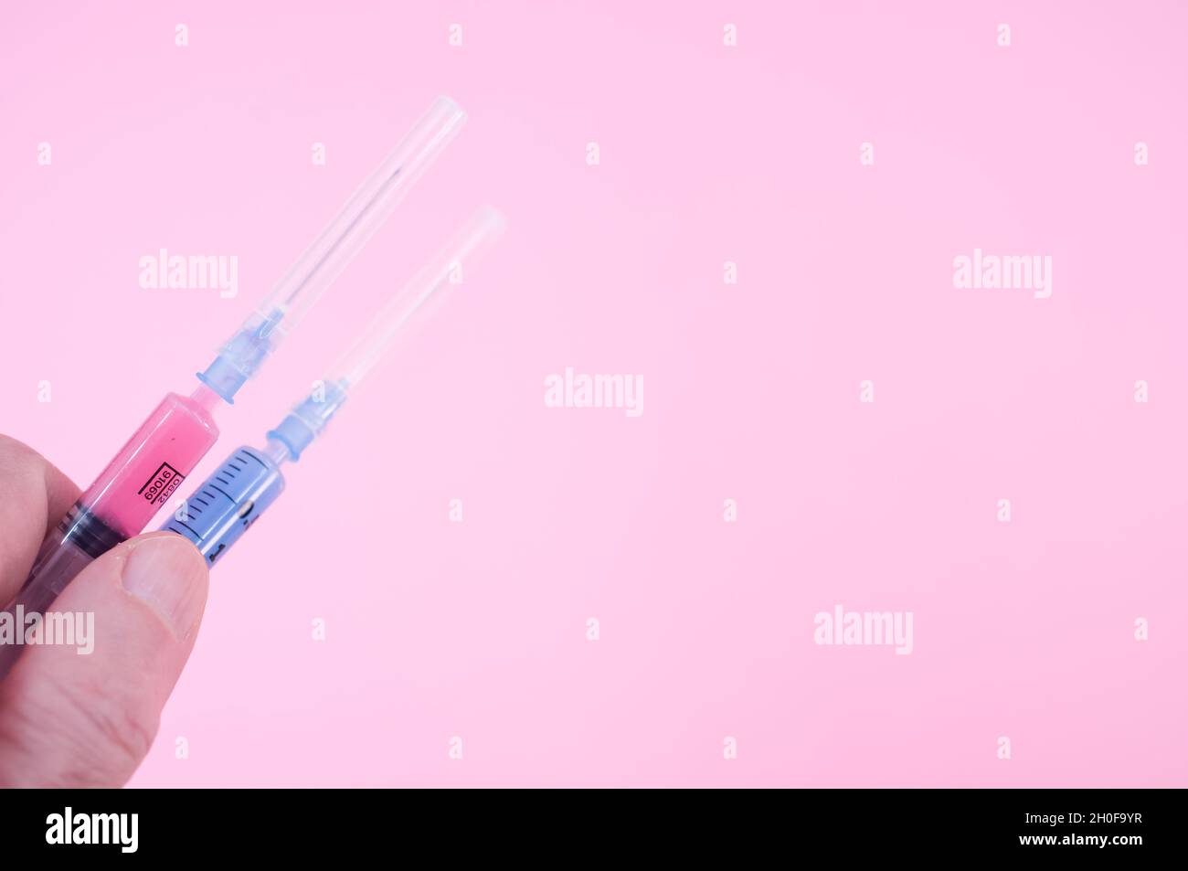 sterilized injection syringe on a pink background Stock Photo - Alamy