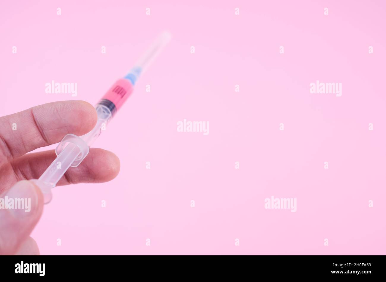 sterilized injection syringe on a pink background Stock Photo - Alamy