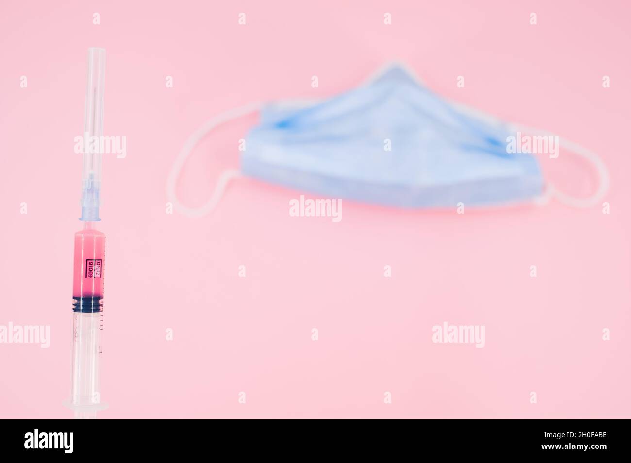 Isolated respiratory mask and syringe on a pink background Stock Photo ...
