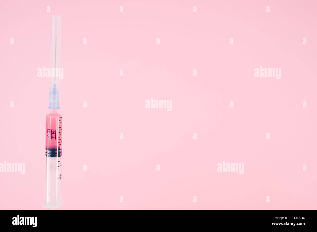 sterilized injection syringe on a pink background Stock Photo - Alamy