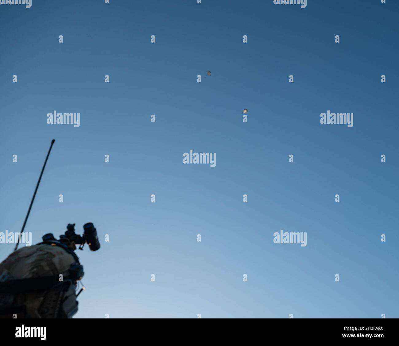 A U.S. Air Force Special Tactics operator watches bundles descend to ...